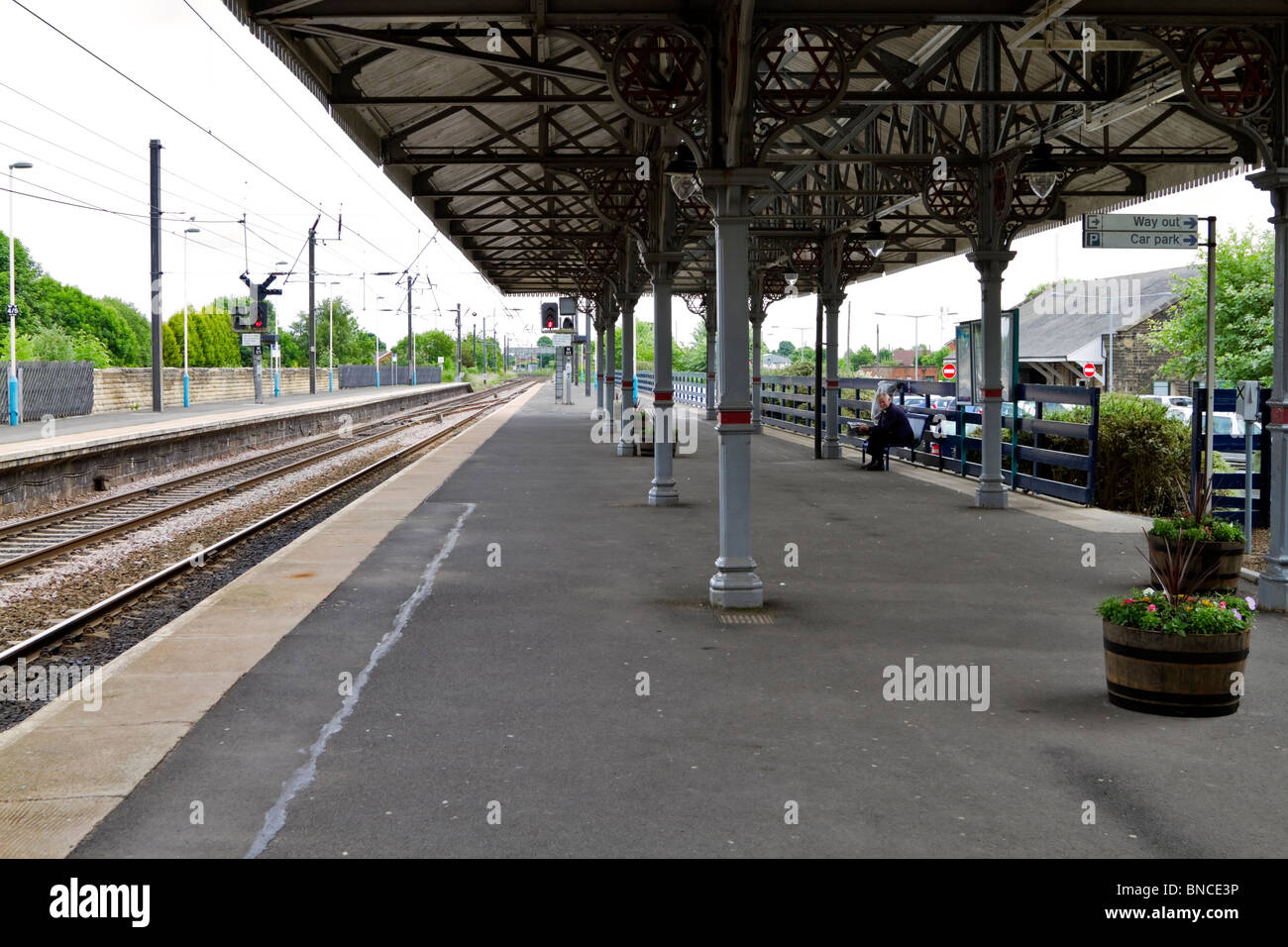 Morpeth Railway Station. One passenger sits on a bench on the empty ...
