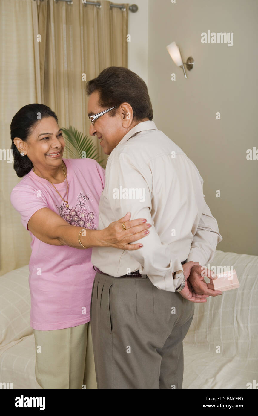 Man hiding a gift behind back Stock Photo - Alamy