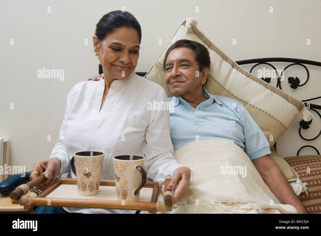 Woman bringing tea for a man Stock Photo - Alamy