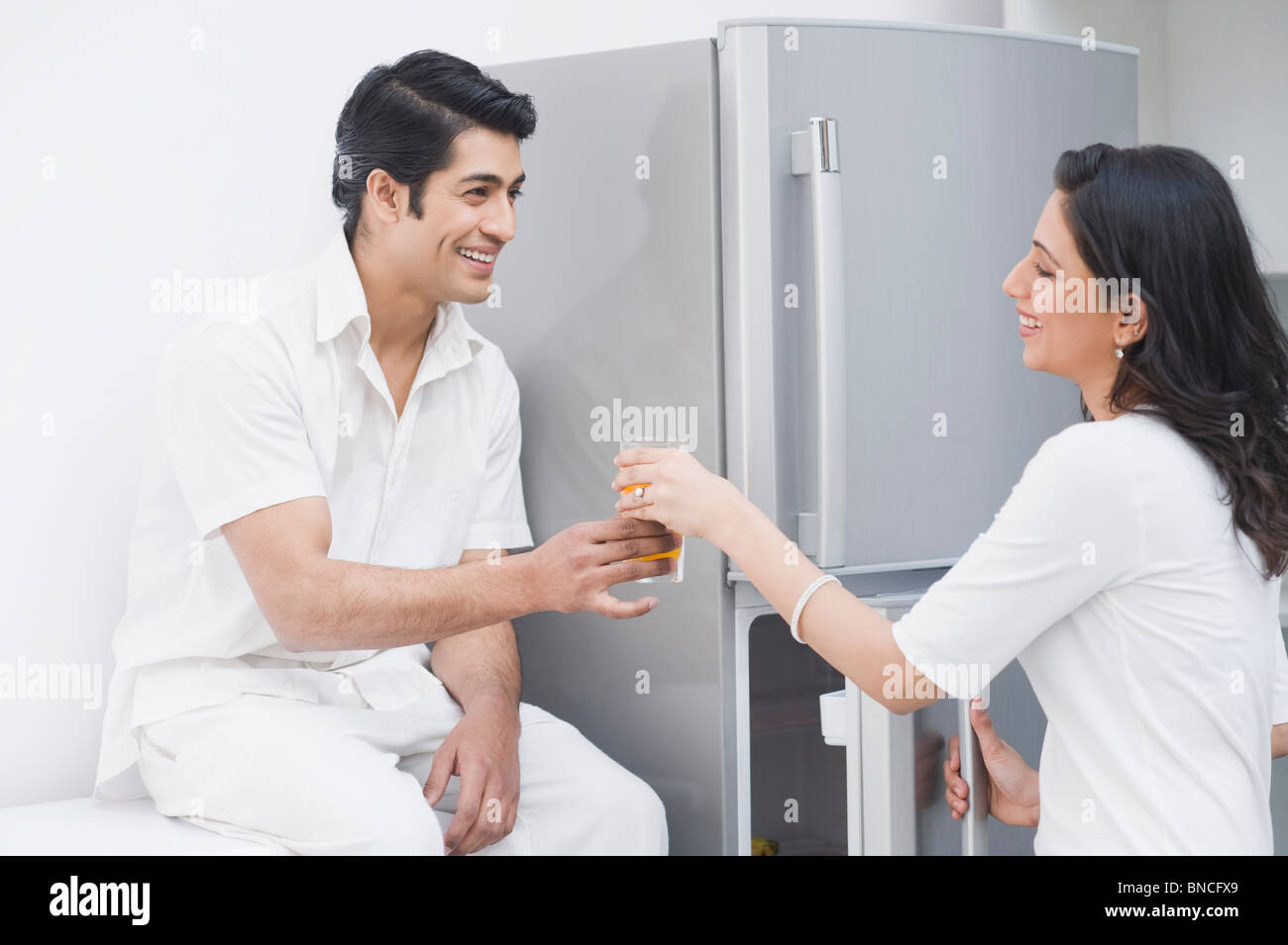 Woman giving orange juice to a man Stock Photo - Alamy