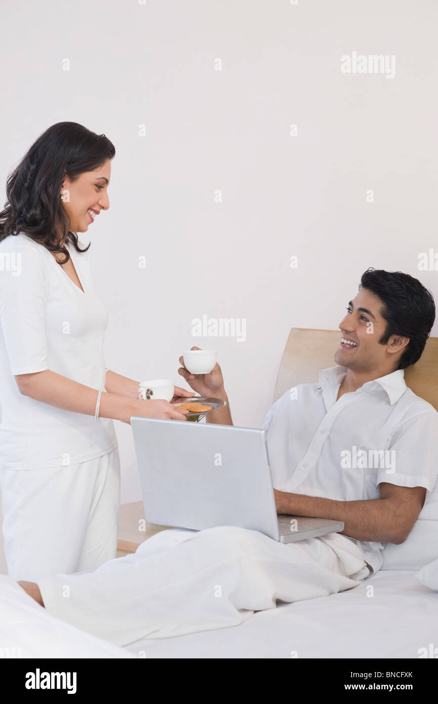 Woman giving tea to her husband Stock Photo - Alamy