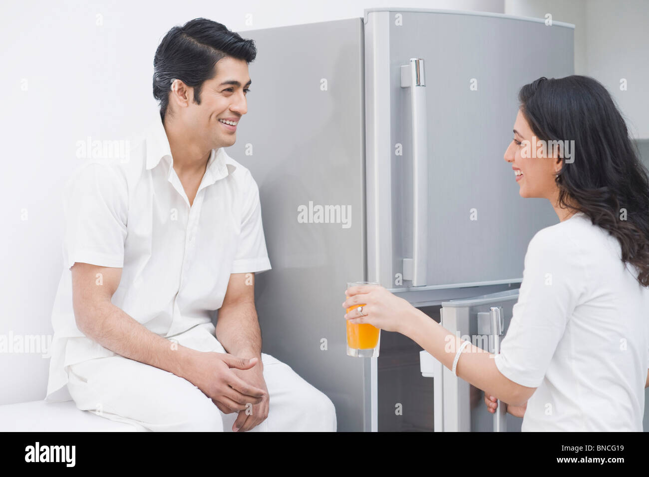 Woman giving orange juice to a man Stock Photo - Alamy