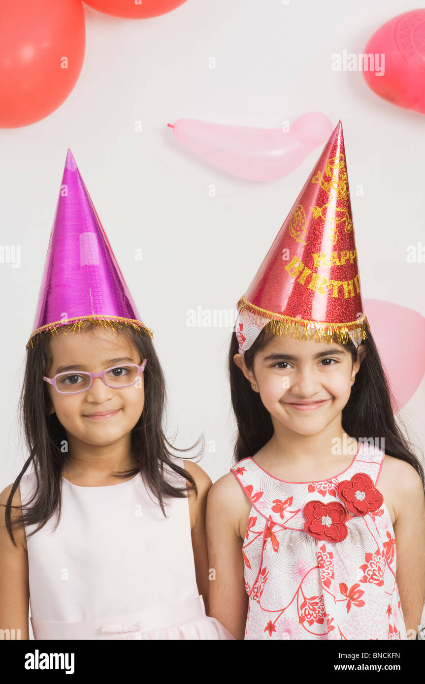 Portrait of two girls wearing party hats Stock Photo - Alamy