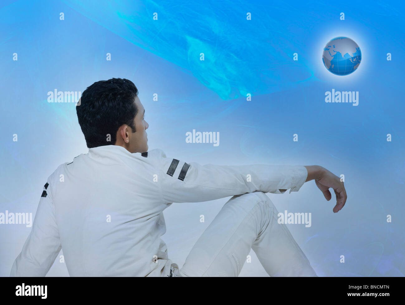 Pilot looking at a globe Stock Photo - Alamy