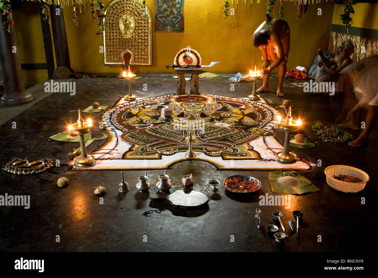 Silver vessels stand ready for a puja (ritual prayer) next to a Kalam ...
