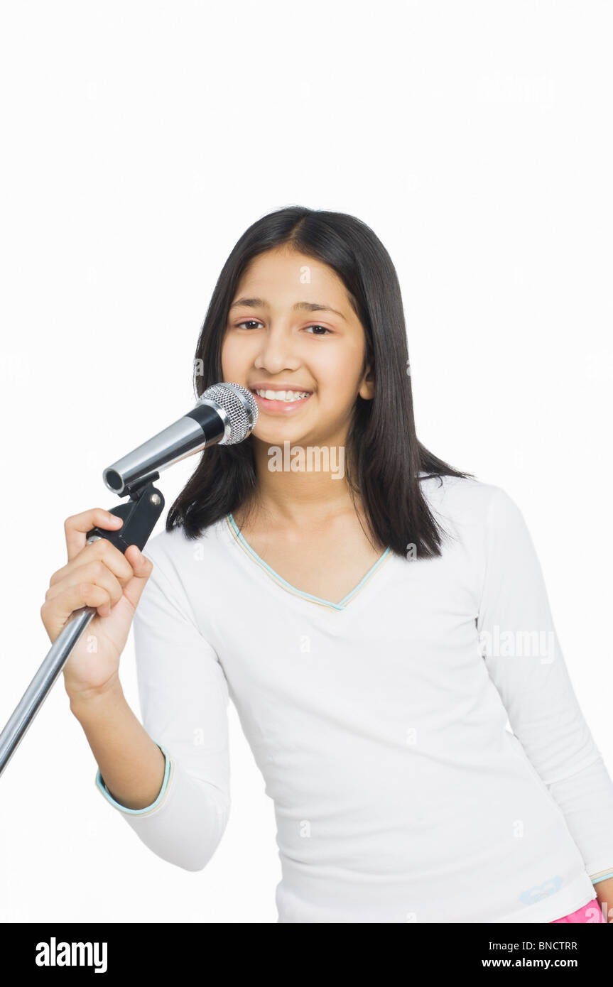 Portrait of a girl singing into a microphone Stock Photo - Alamy