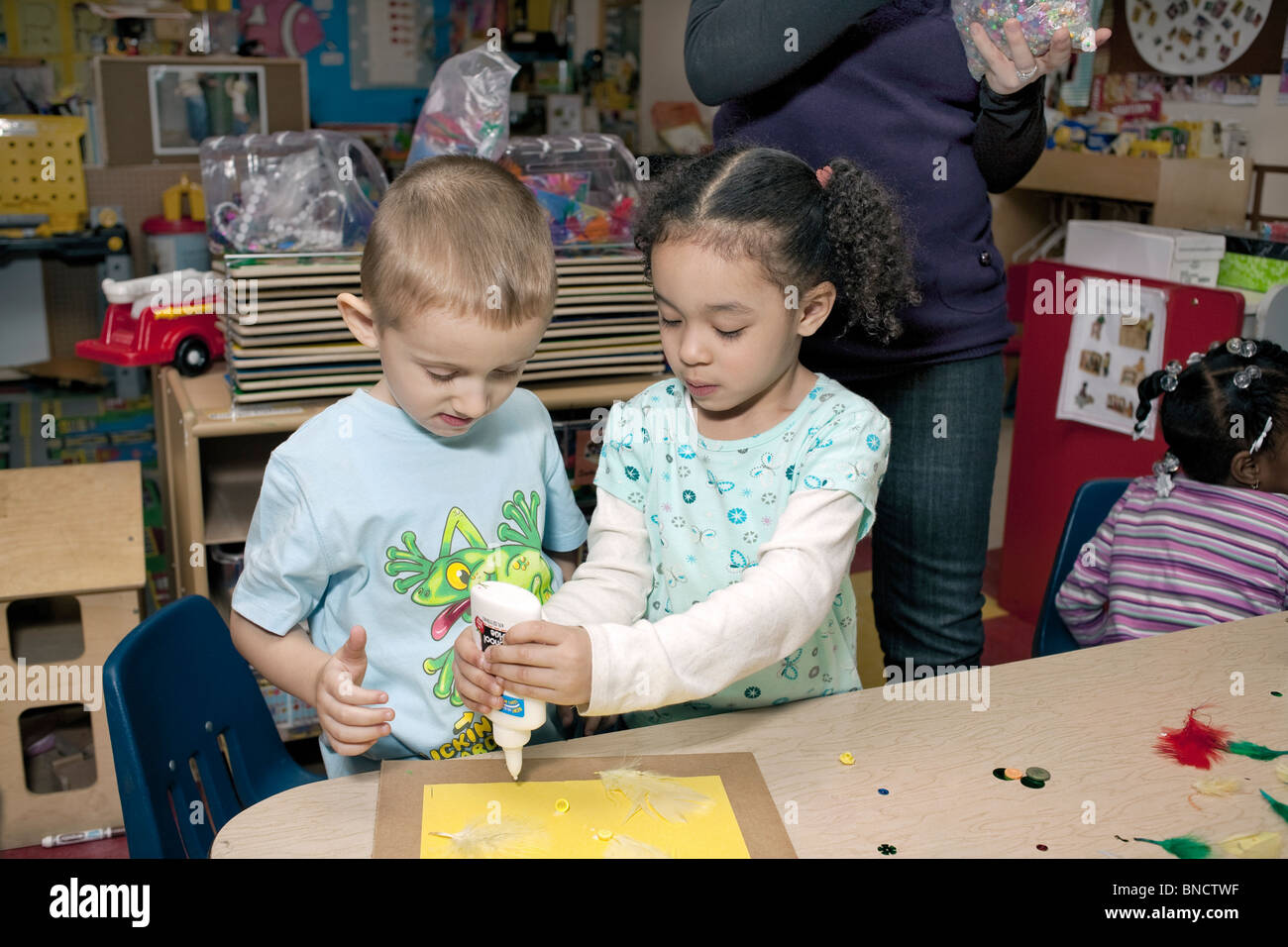 preschool girl and boy with glue Stock Photo - Alamy