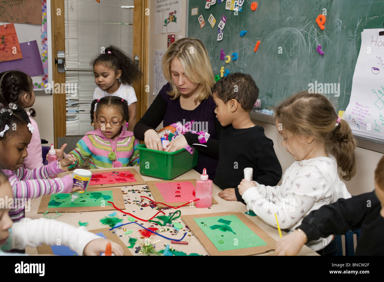 preschool teacher with students in classroom Stock Photo - Alamy