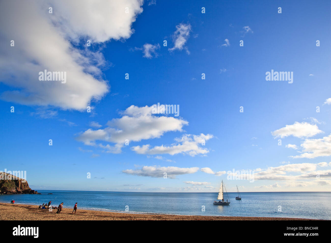 Blackpool Sands Devon beach scene with small yacht on sea with blue sky ...