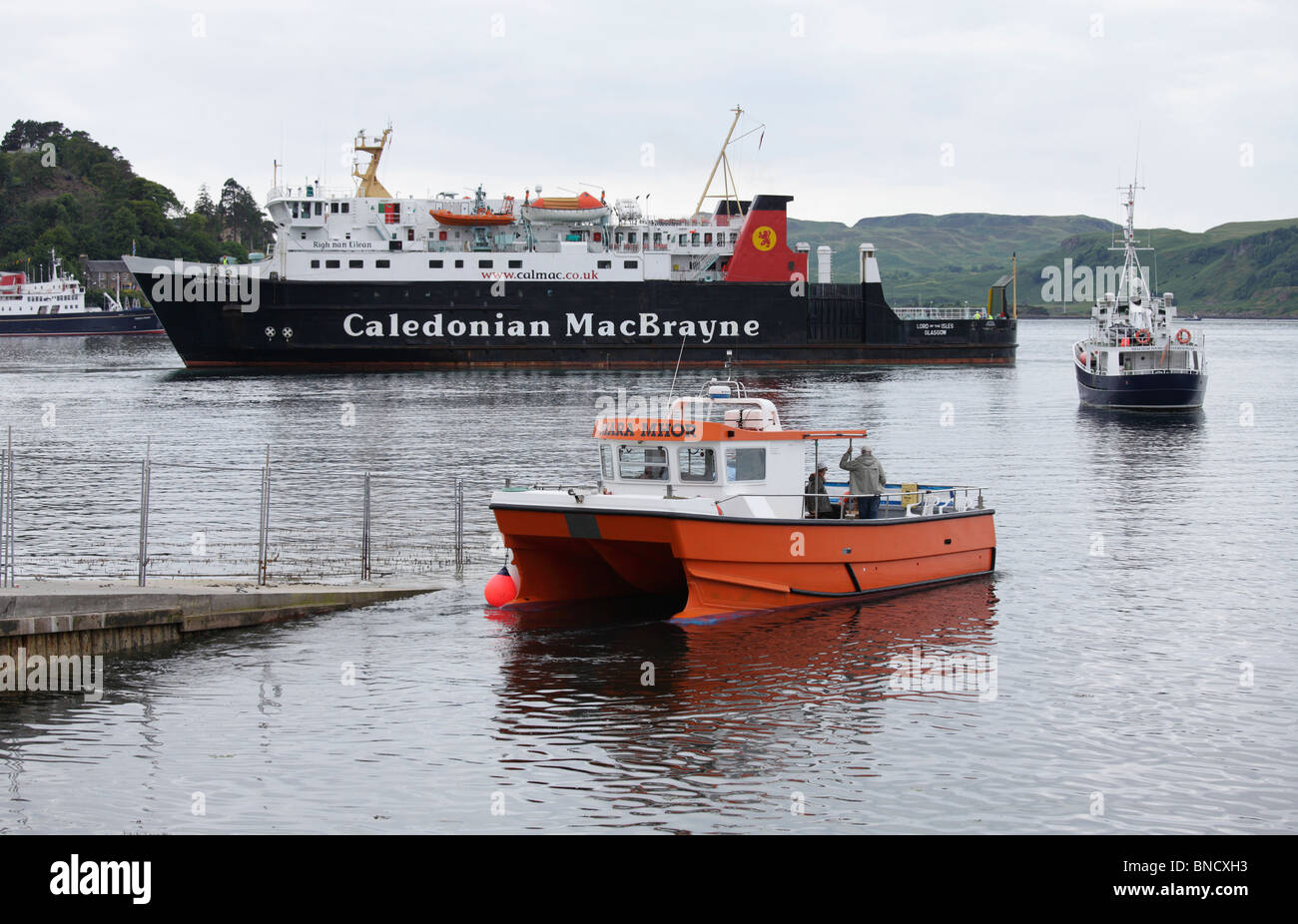 A ferry entering Oban with two smaller boats in front Stock Photo - Alamy