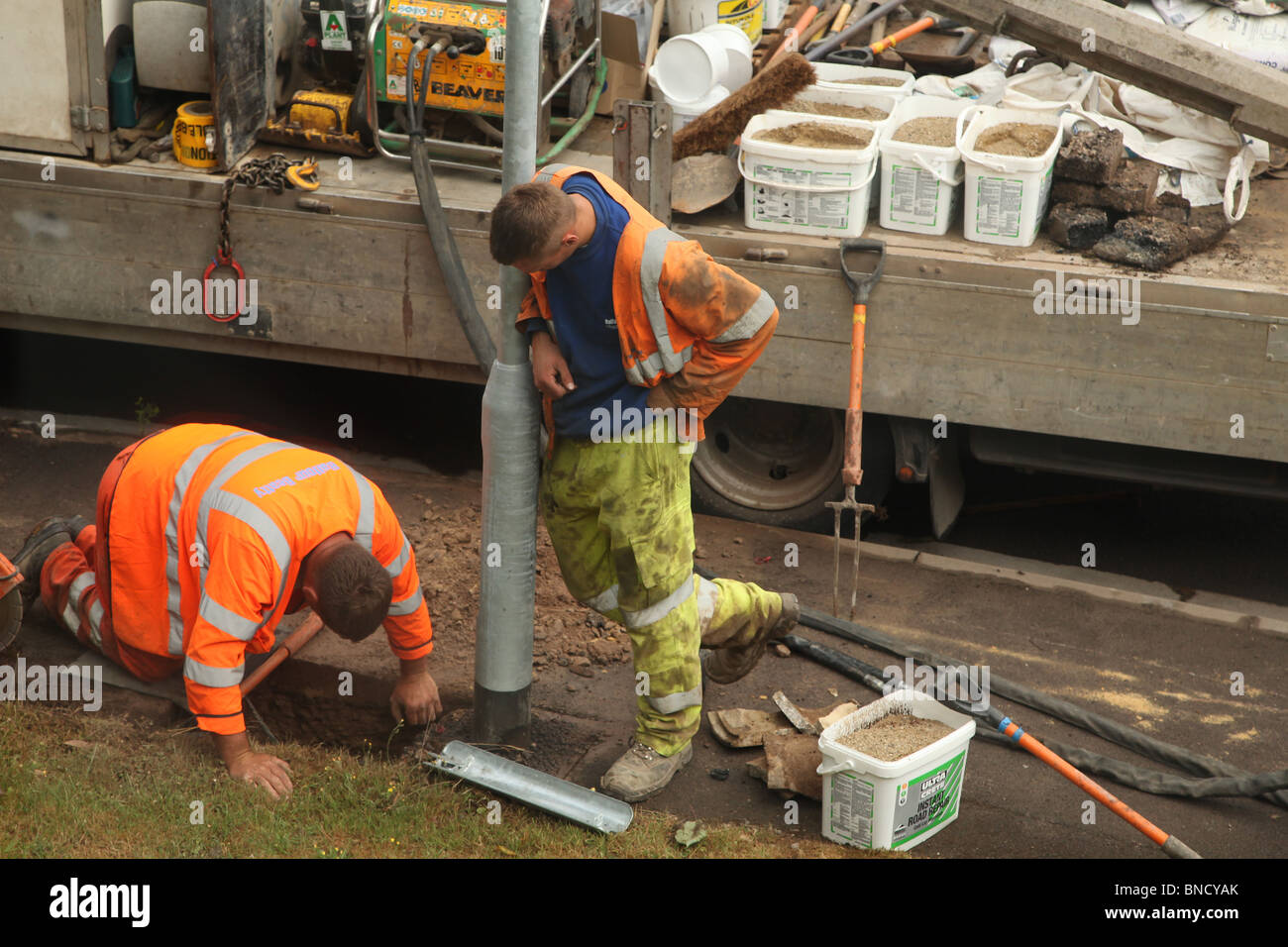 Two men from the council replacing a lamp post Stock Photo - Alamy