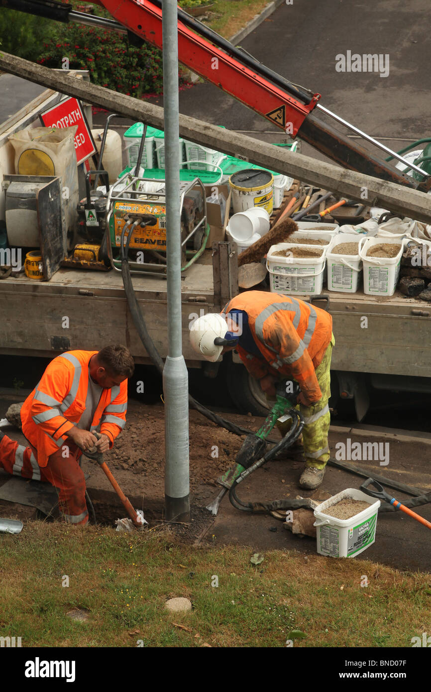 Two men from the council replacing a lamp post Stock Photo - Alamy