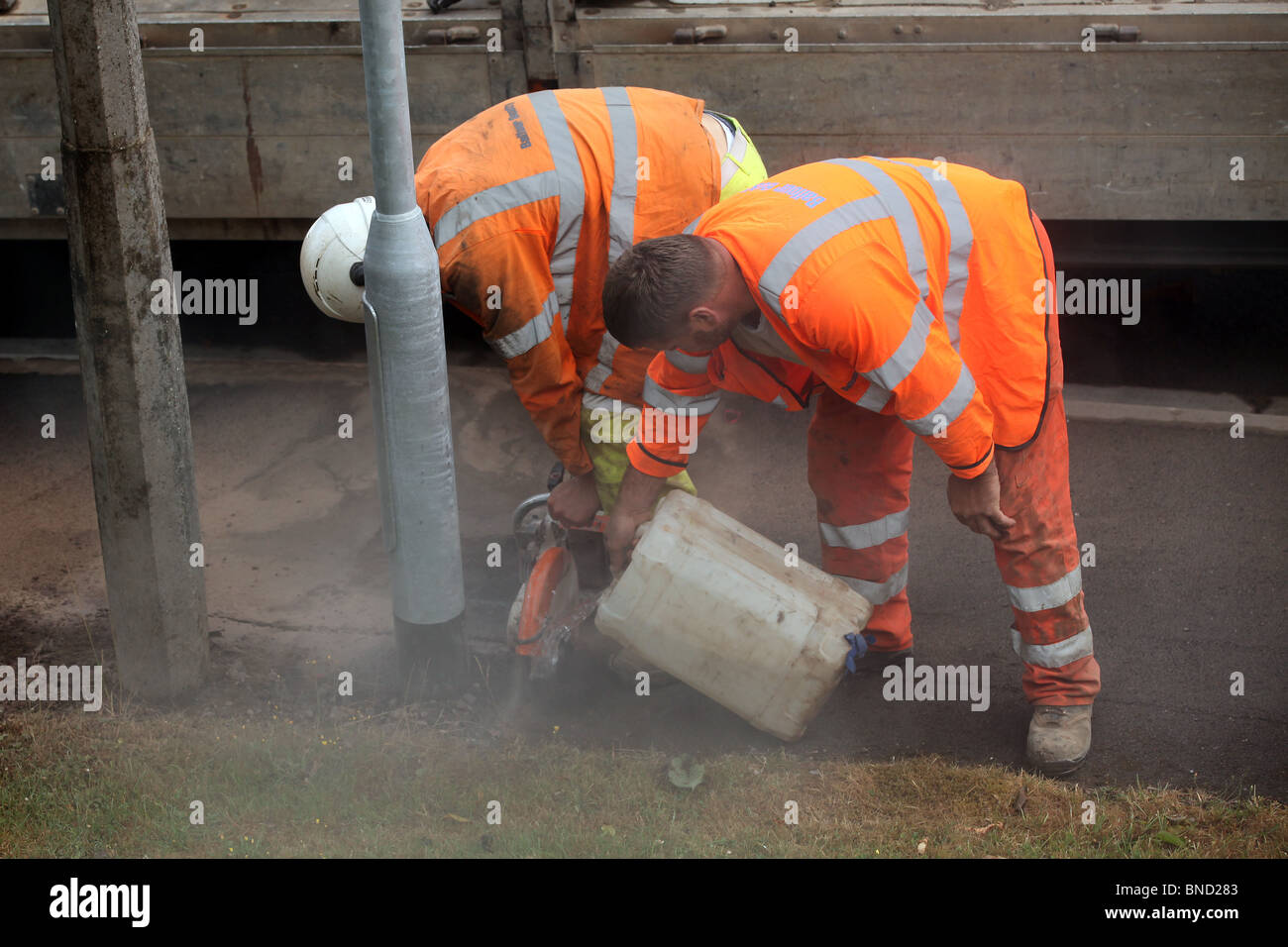 Two men from the council replacing a lamp post Stock Photo - Alamy