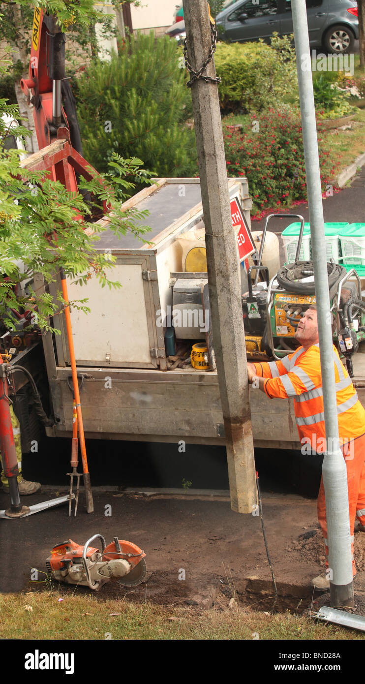 Two men from the council replacing a lamp post Stock Photo - Alamy