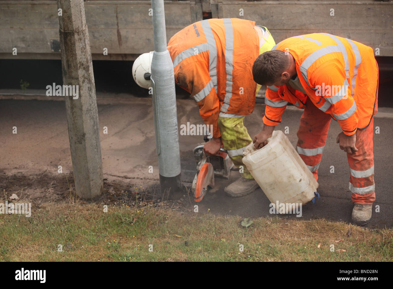 Two men from the council replacing a lamp post Stock Photo - Alamy