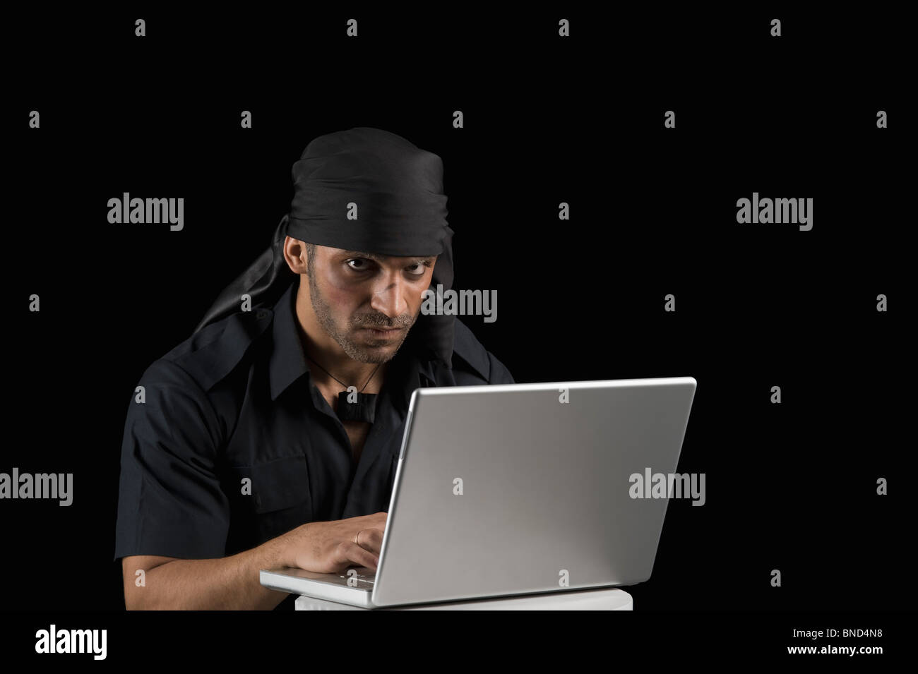 Actor portraying a villain using a laptop Stock Photo - Alamy