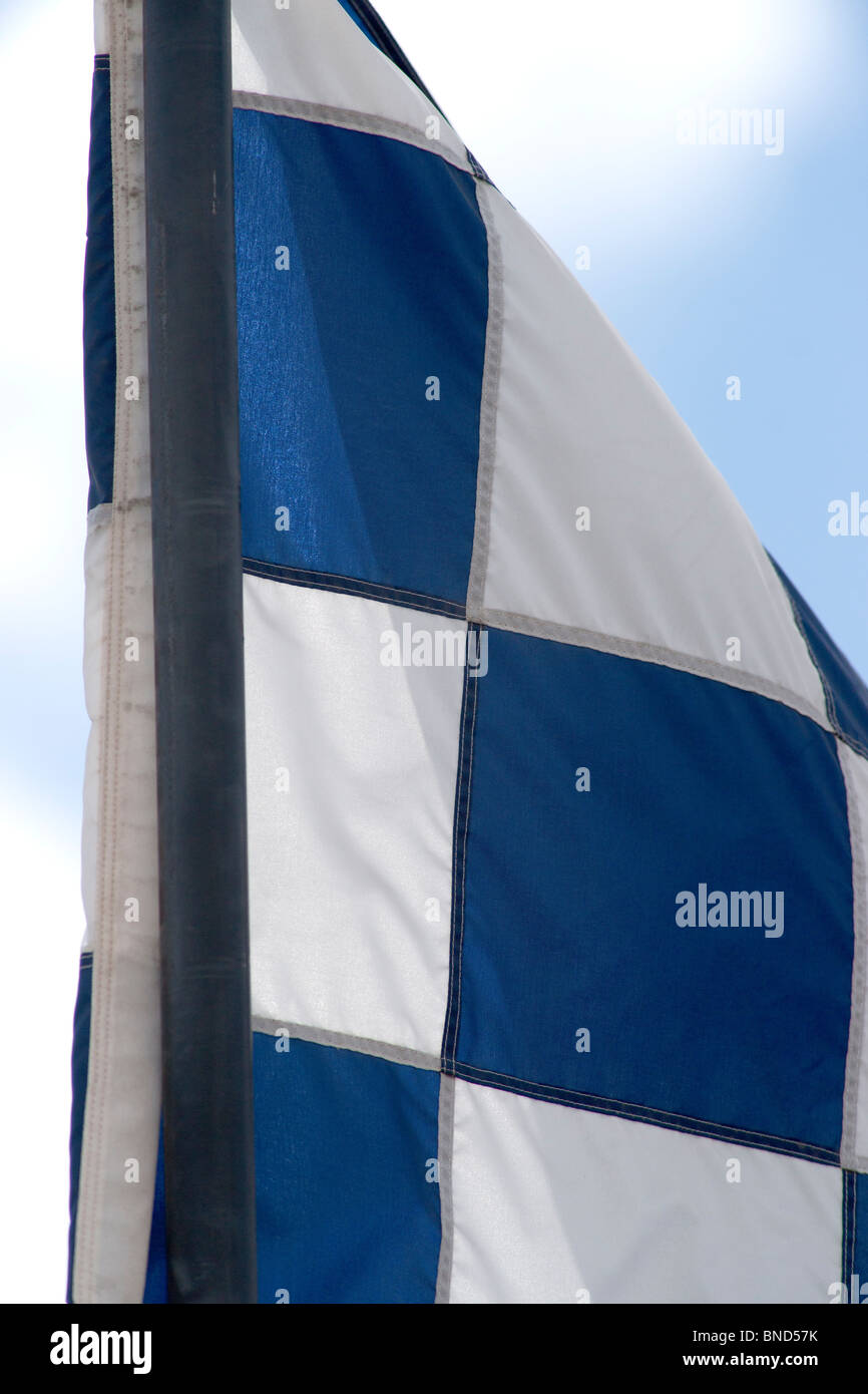 A white and blue checkered flag waving in a breeze Stock Photo - Alamy