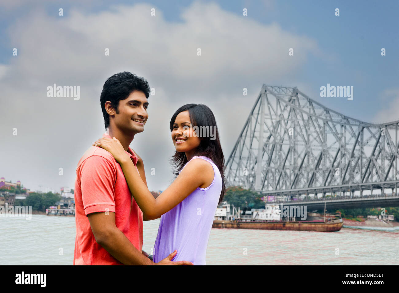 Couple smiling with a bridge in the background, Howrah Bridge, Hooghly ...