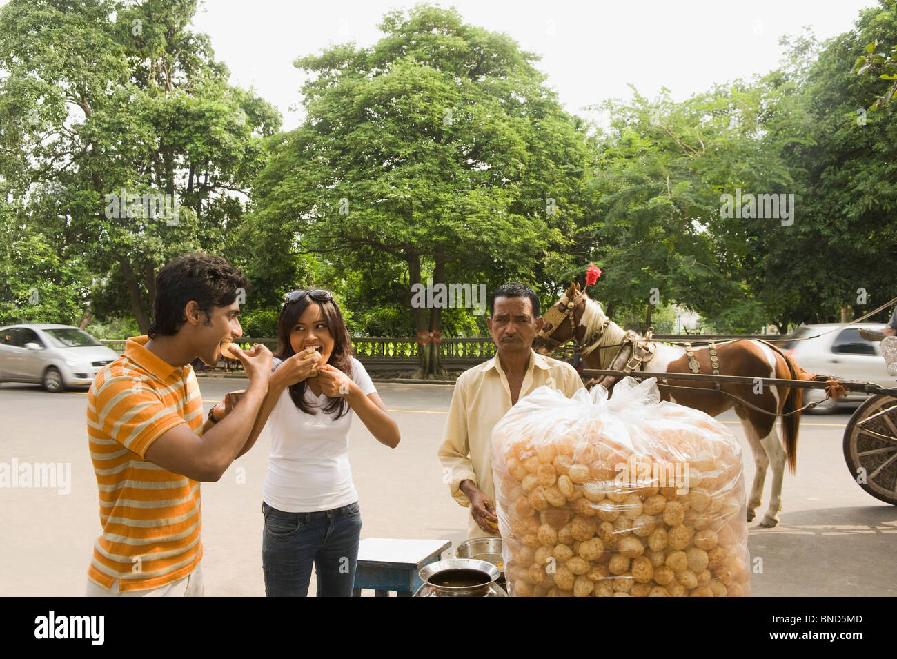 Vendor serving Indian snack panipuri to a couple on a street, Kolkata ...