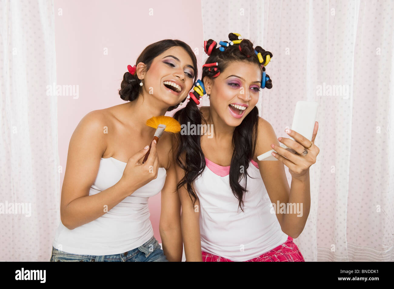 Two women applying make-up Stock Photo - Alamy