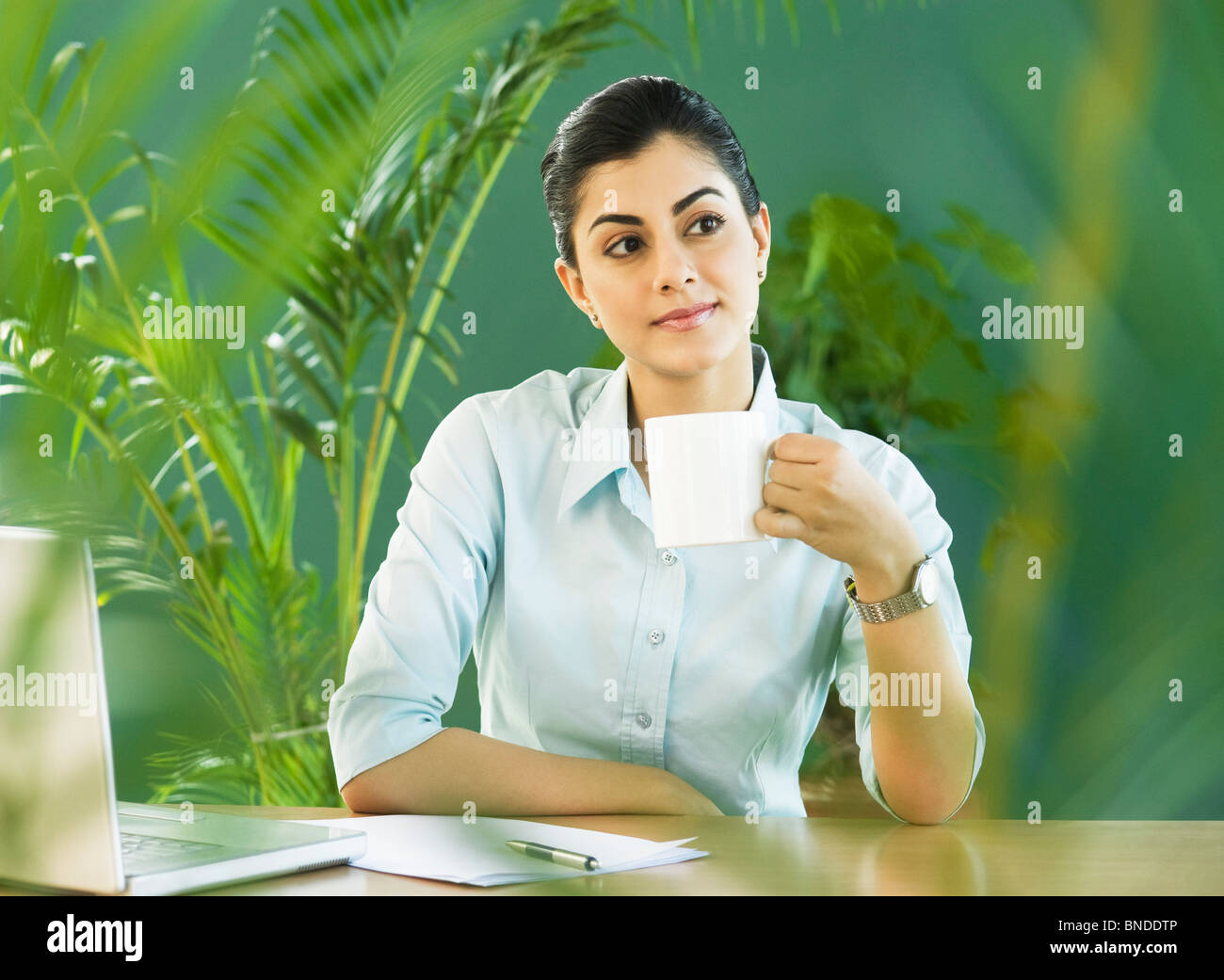Businesswoman drinking tea in an office Stock Photo - Alamy