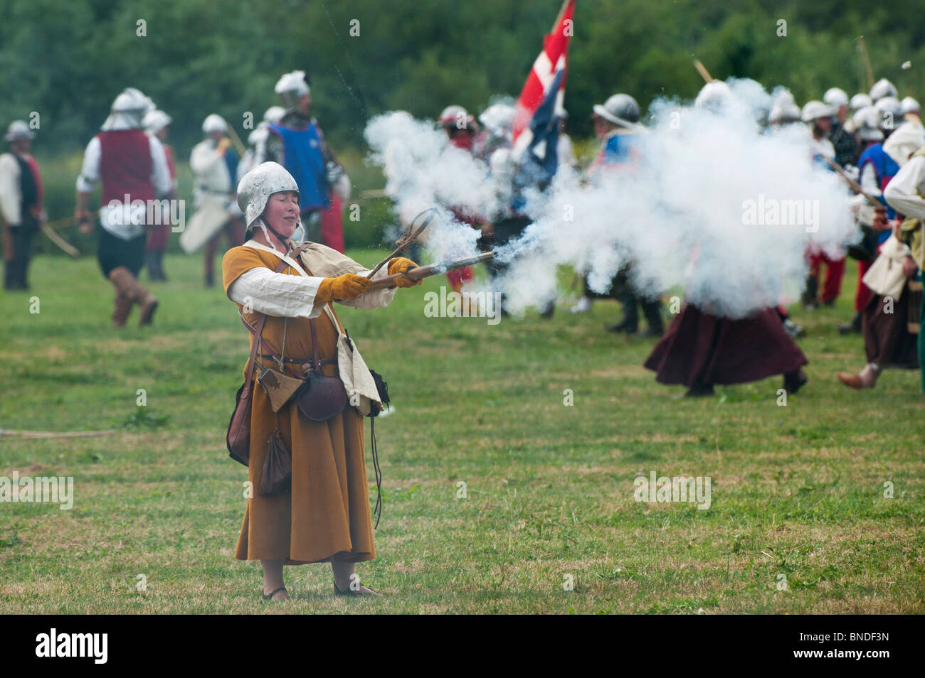 Medieval female gunner firing a handgonne on the battlefield at the ...