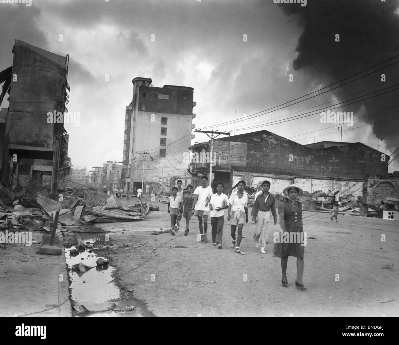 Group of people walking in front of burning buildings, Manila ...