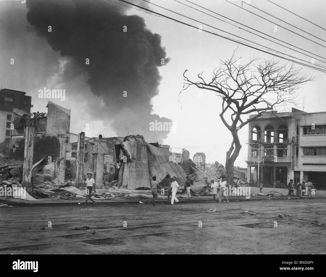 Group of people walking in front of burning buildings, Manila ...