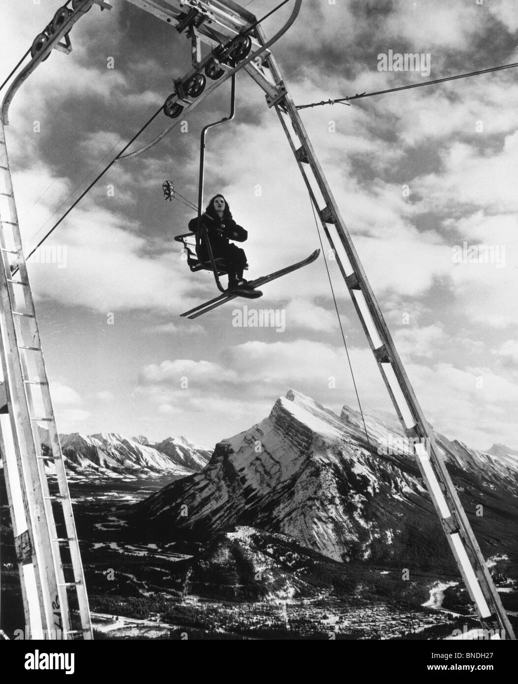 Low angle view of a woman sitting on a ski lift, Banff National Park ...