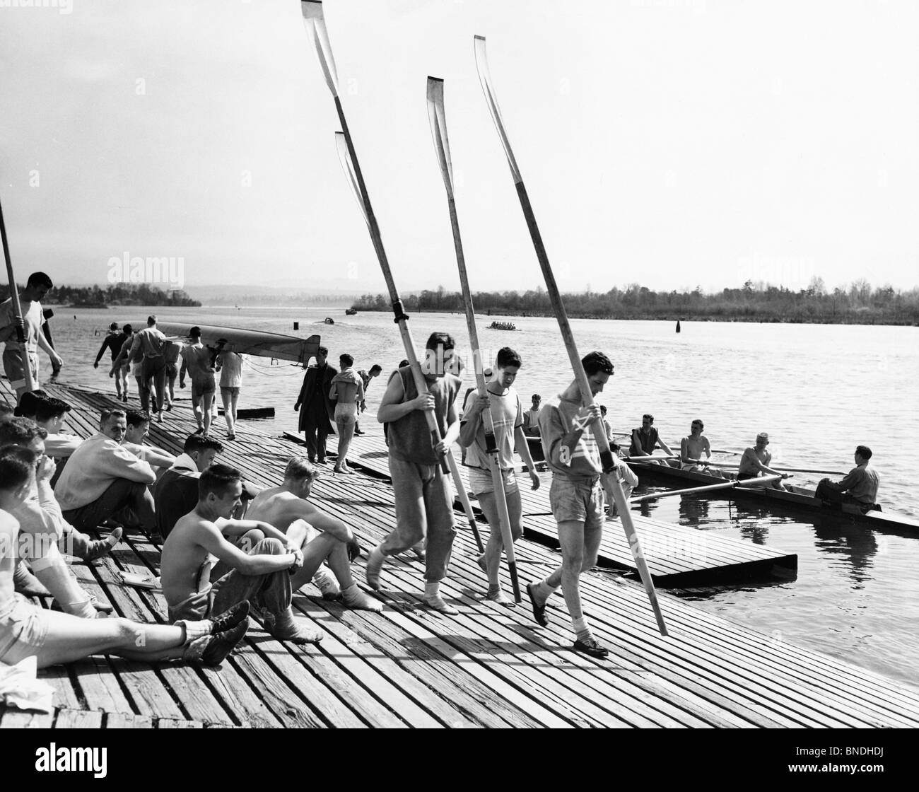 Tourists on a boardwalk with men carrying oars Stock Photo - Alamy