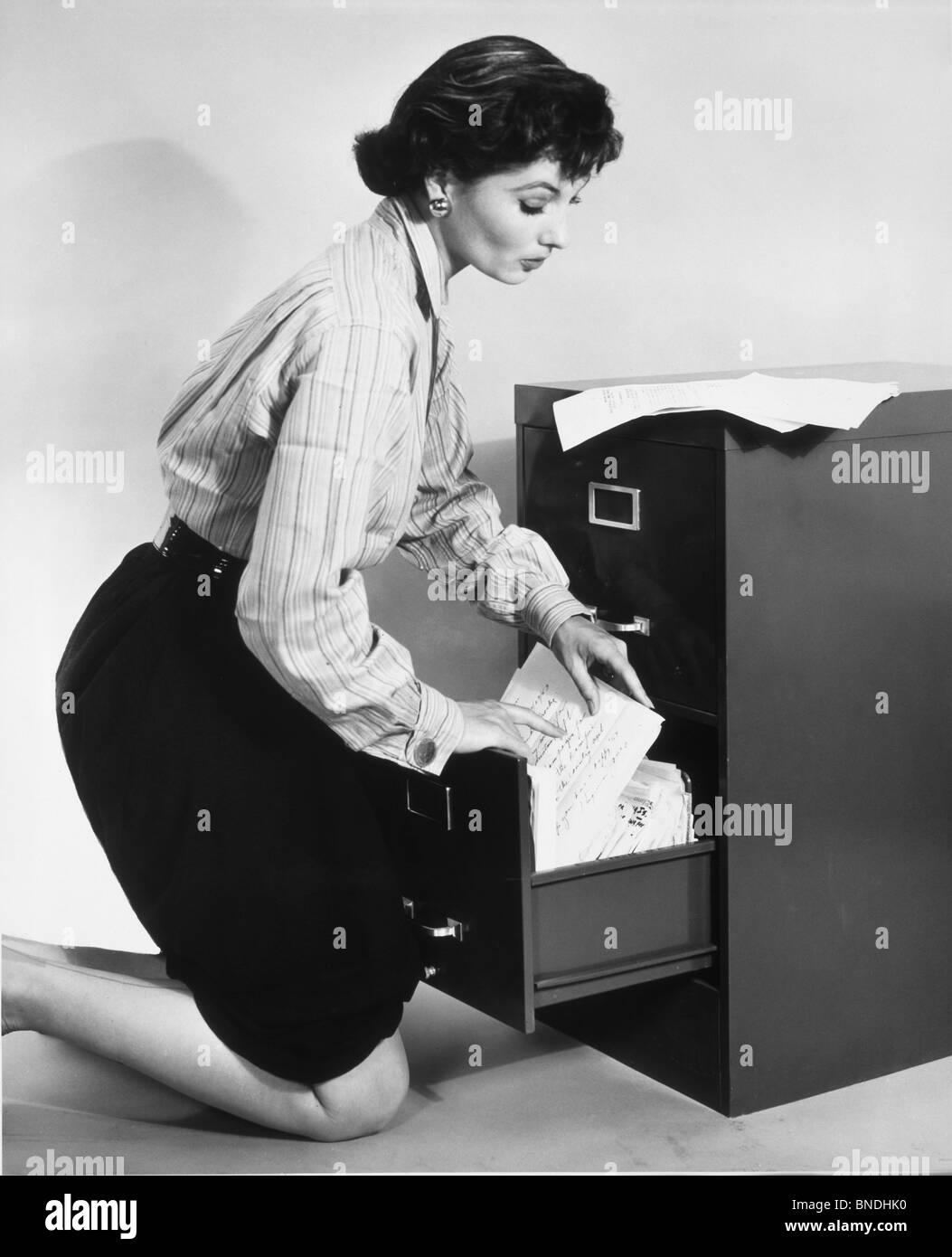 A woman filing documents into a cabinet hi-res stock photography and ...