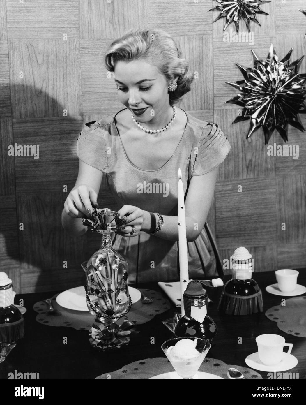 Young woman setting a dining table Stock Photo - Alamy
