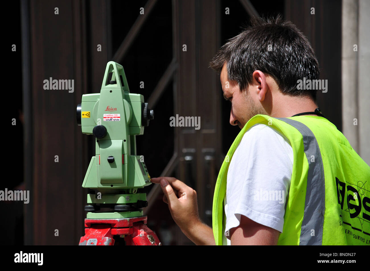 Male surveyor working with automatic level, Regent Street, City of ...