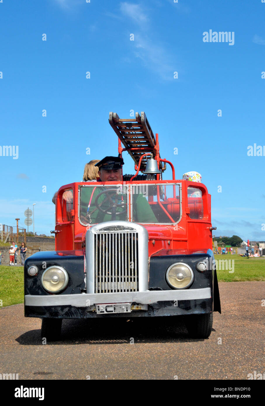 A miniature 1950's fire engine. A driver prepares to take a few ...