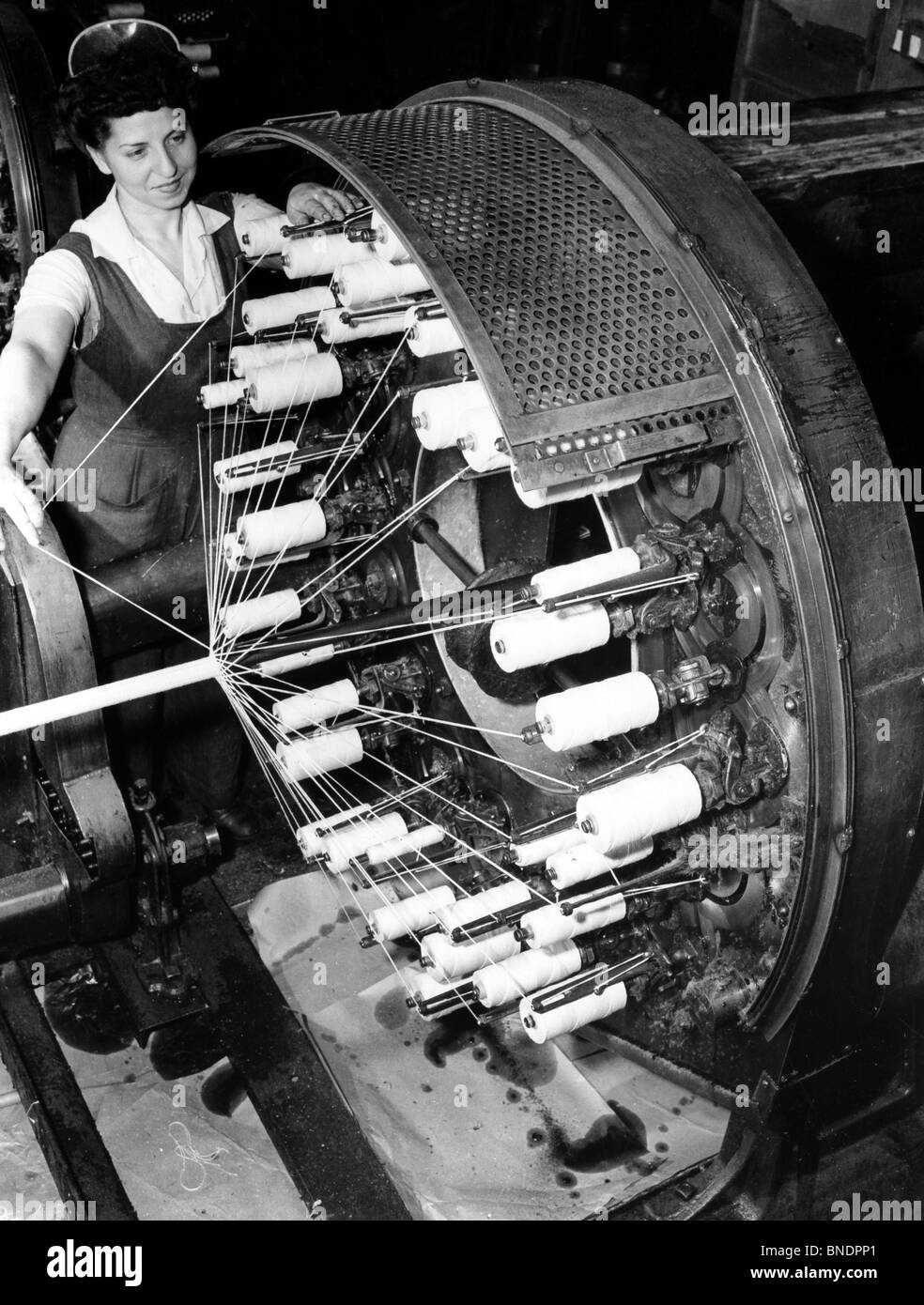 Mid adult woman working on a spool in a textile industry, 1945 Stock ...