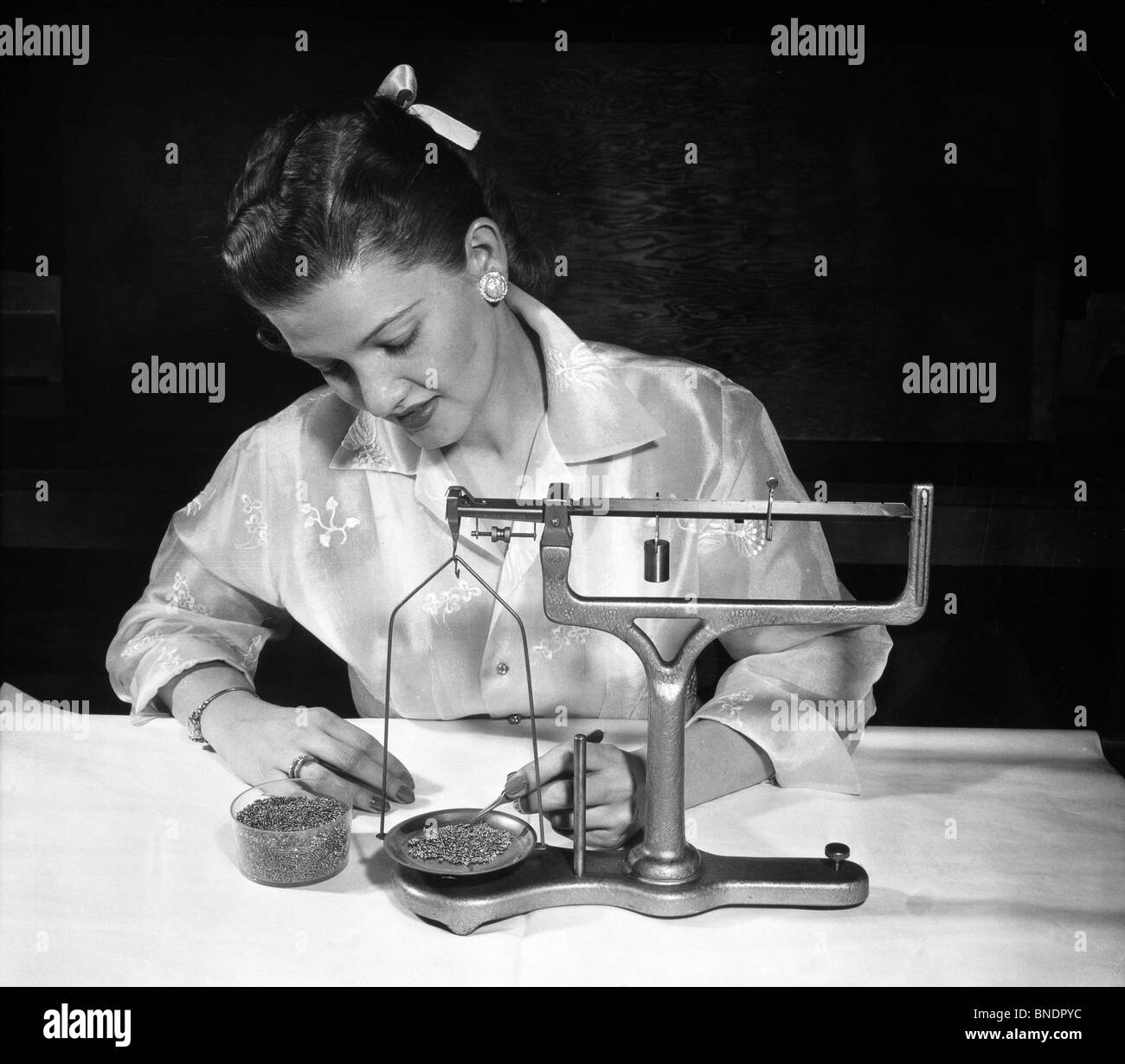 Young woman counting and weighing pearls Stock Photo - Alamy