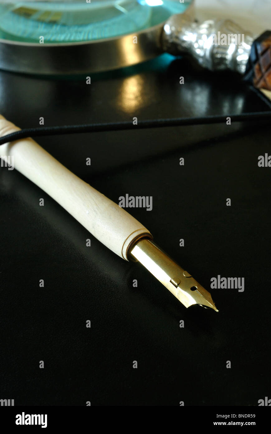 A dip calligraphy pen laying on top of a notepad Stock Photo - Alamy