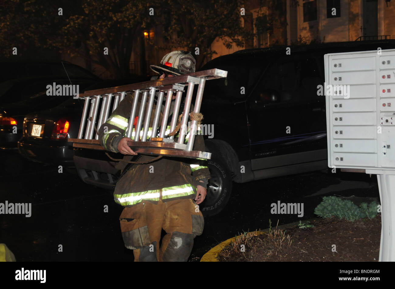 Firefighter carrying a ladder Stock Photo - Alamy