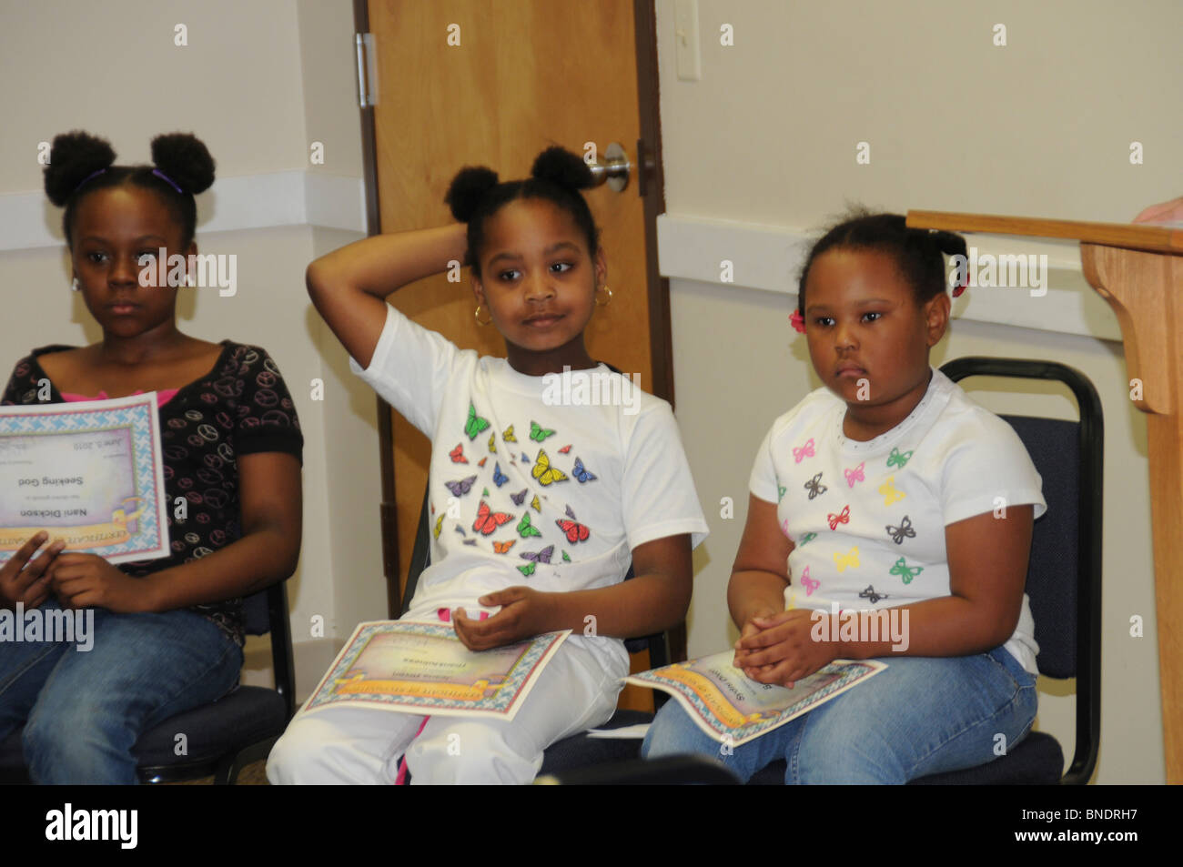 3 small children at a school at a parent teacher open house in ...