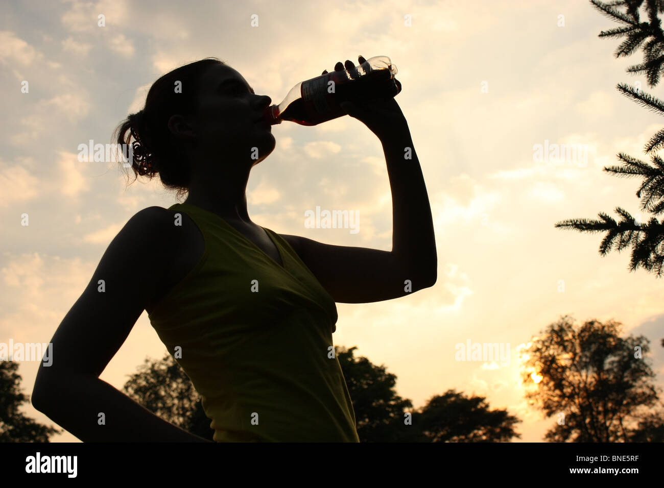 girl drinking water sunset shadow silhouette Stock Photo - Alamy