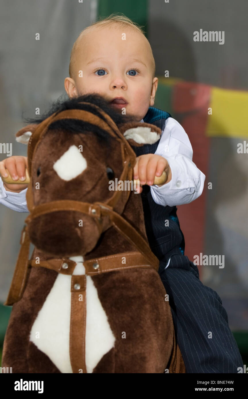 Little boy playing with his rocking horse toy at his first birthday ...