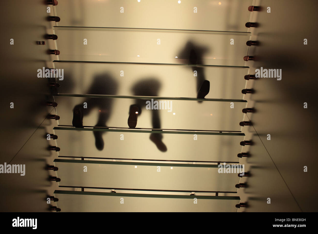 A view of people walking from underneath a transparent walkway in the ...