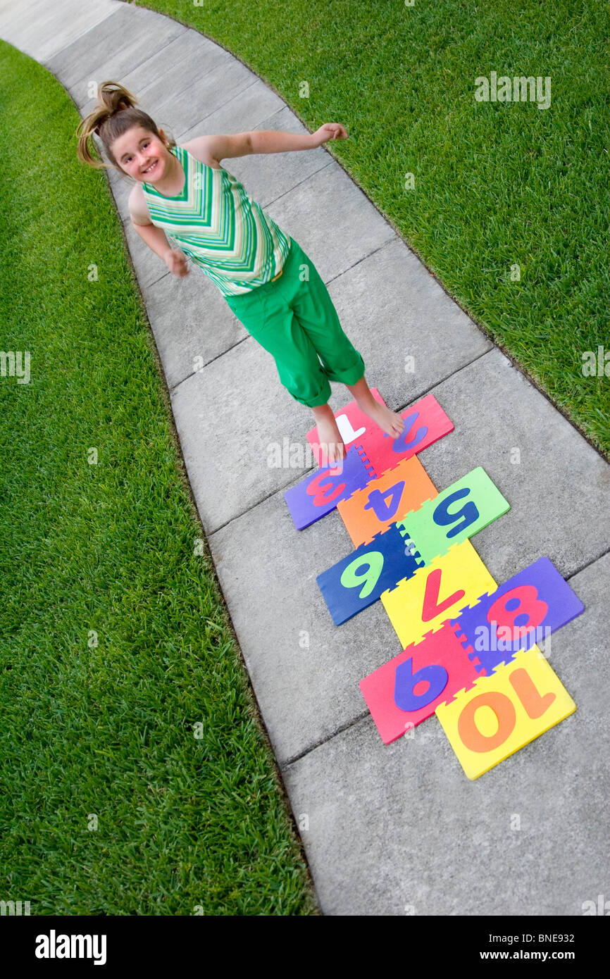 Girl playing hopscotch in a lawn Stock Photo - Alamy