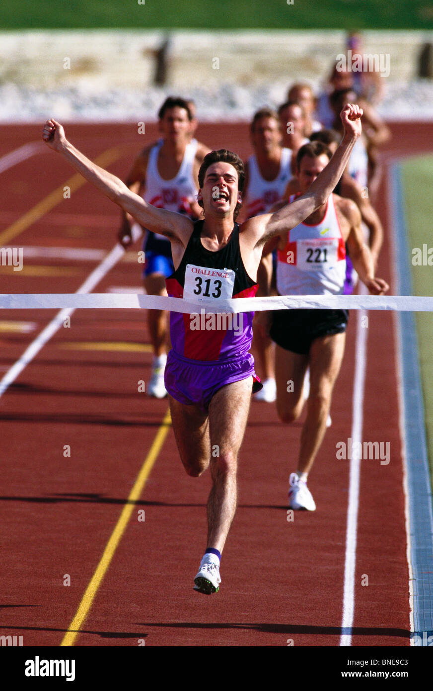 Male runner victorious at the finish line in a track race Stock Photo ...