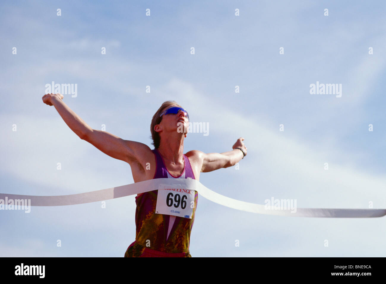 Male runner victorious at the finish line in a track race Stock Photo ...