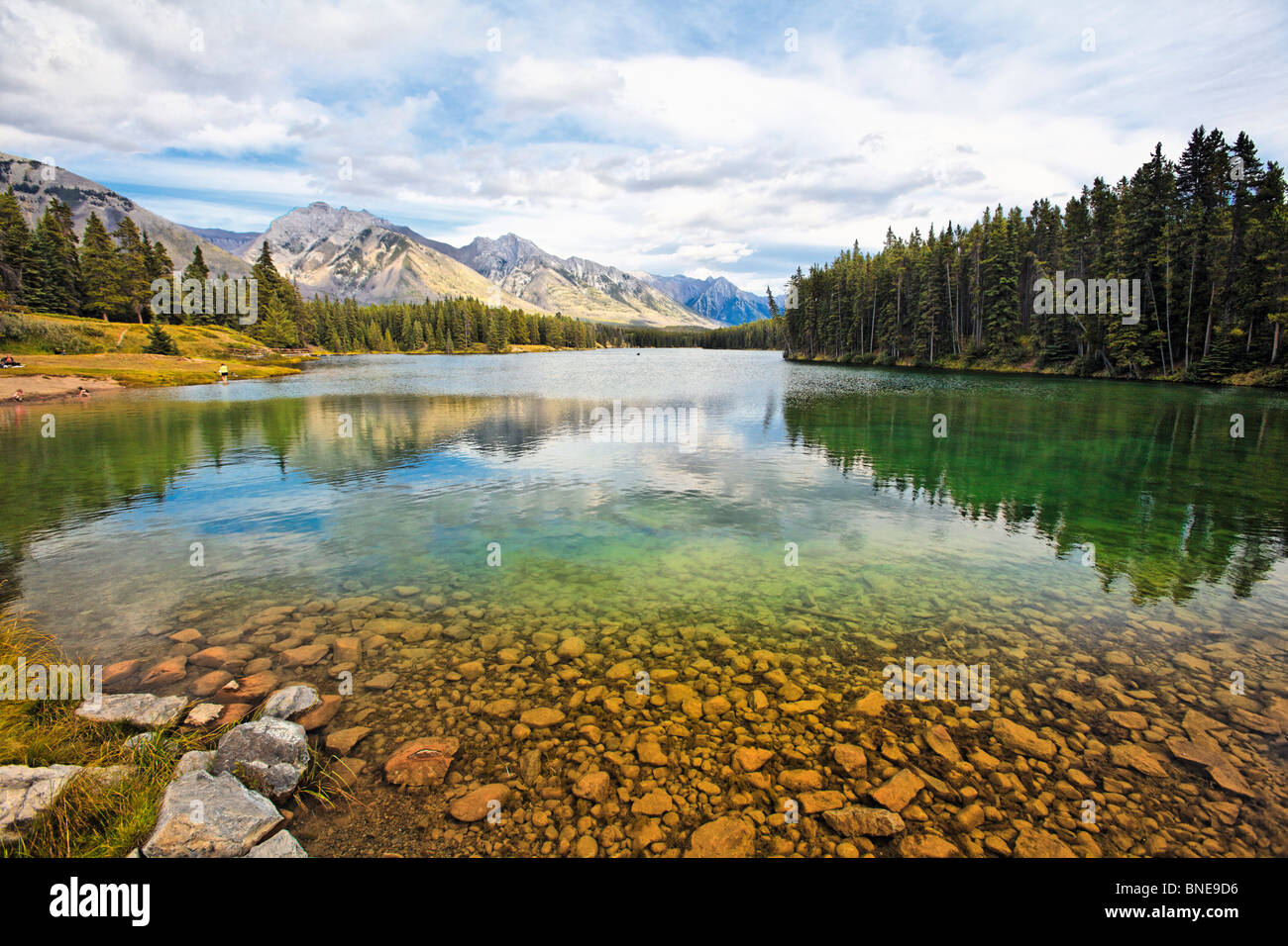 Reflection of mountains and trees in a lake, Lake Johnson, Banff ...