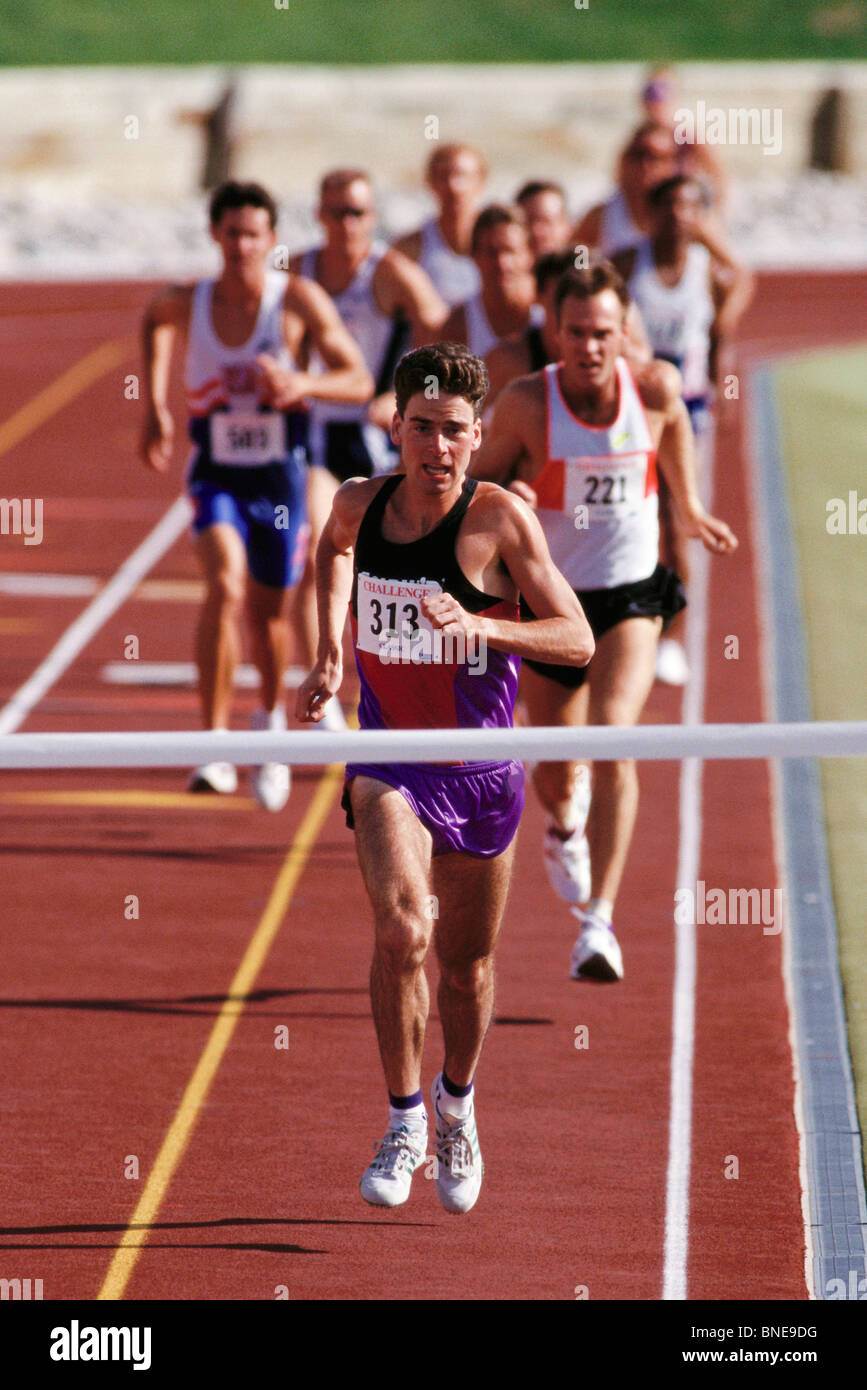 Male runner victorious at the finish line in a track race Stock Photo ...