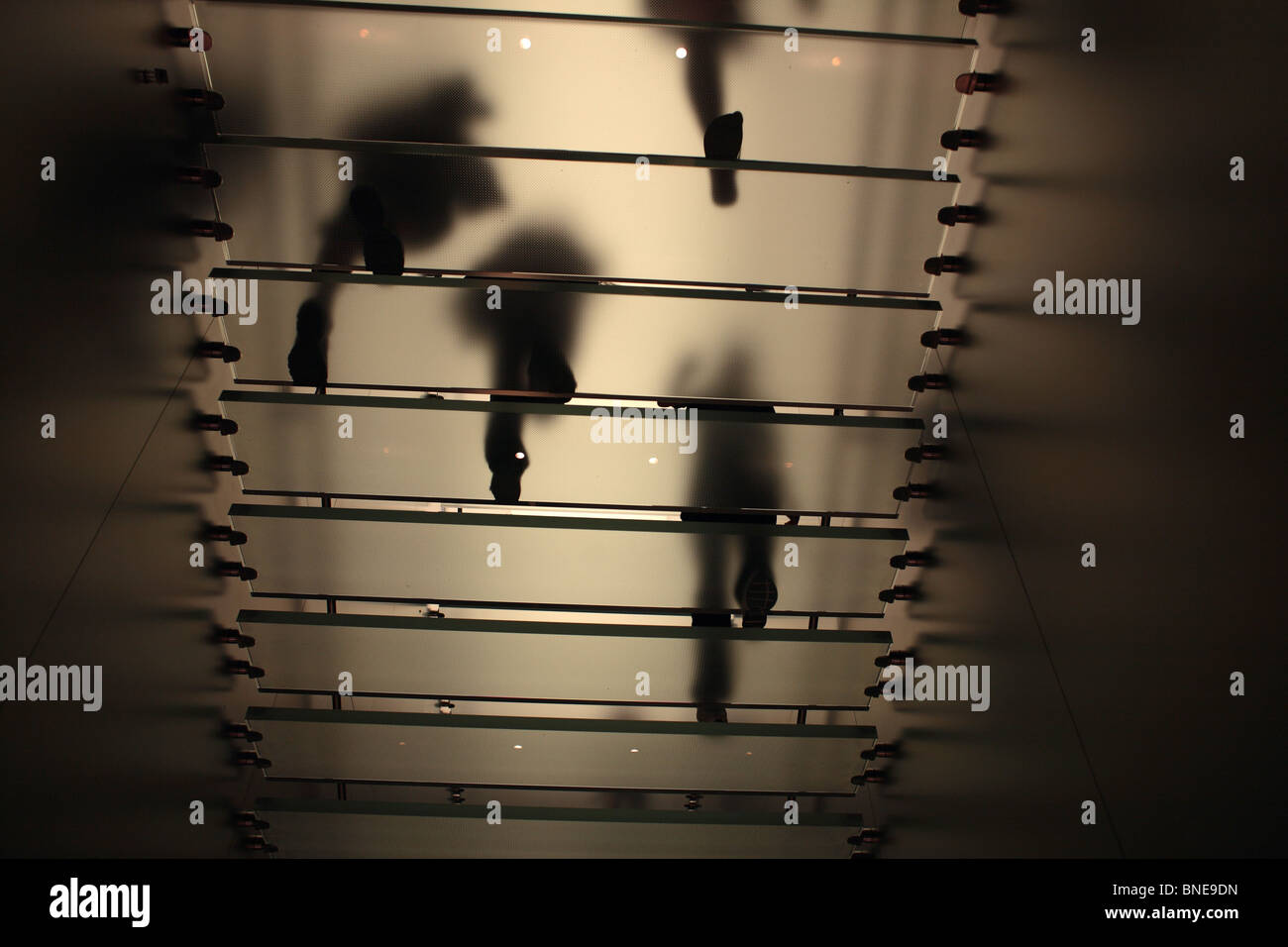 A view of people walking from underneath a transparent walkway in the ...