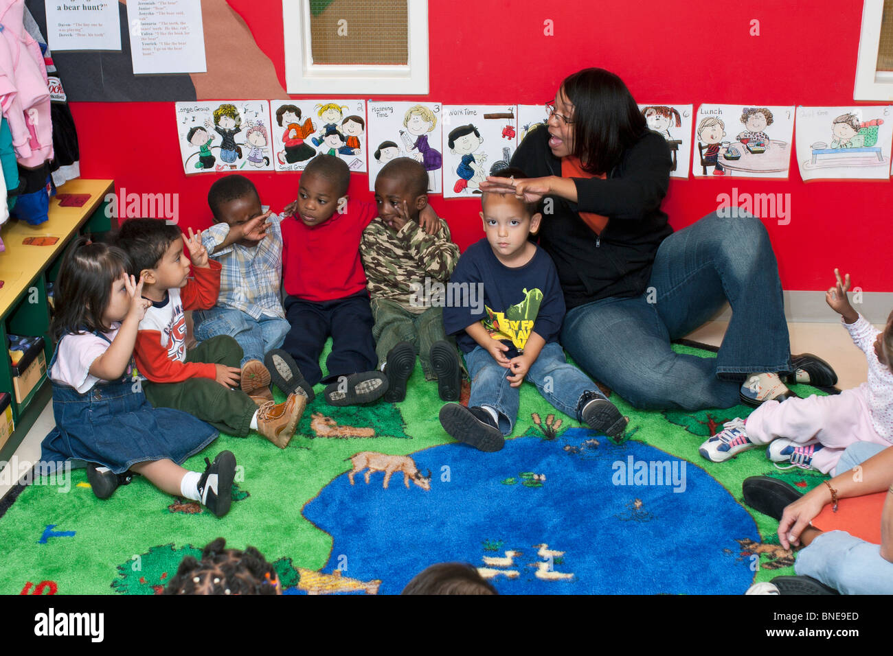 African American preschool teacher showing her students how to count in ...