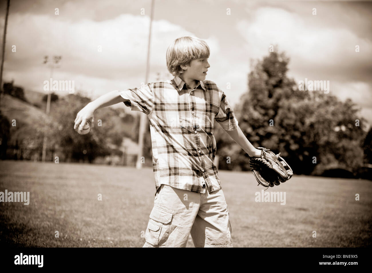 Boy playing baseball in a field Stock Photo - Alamy